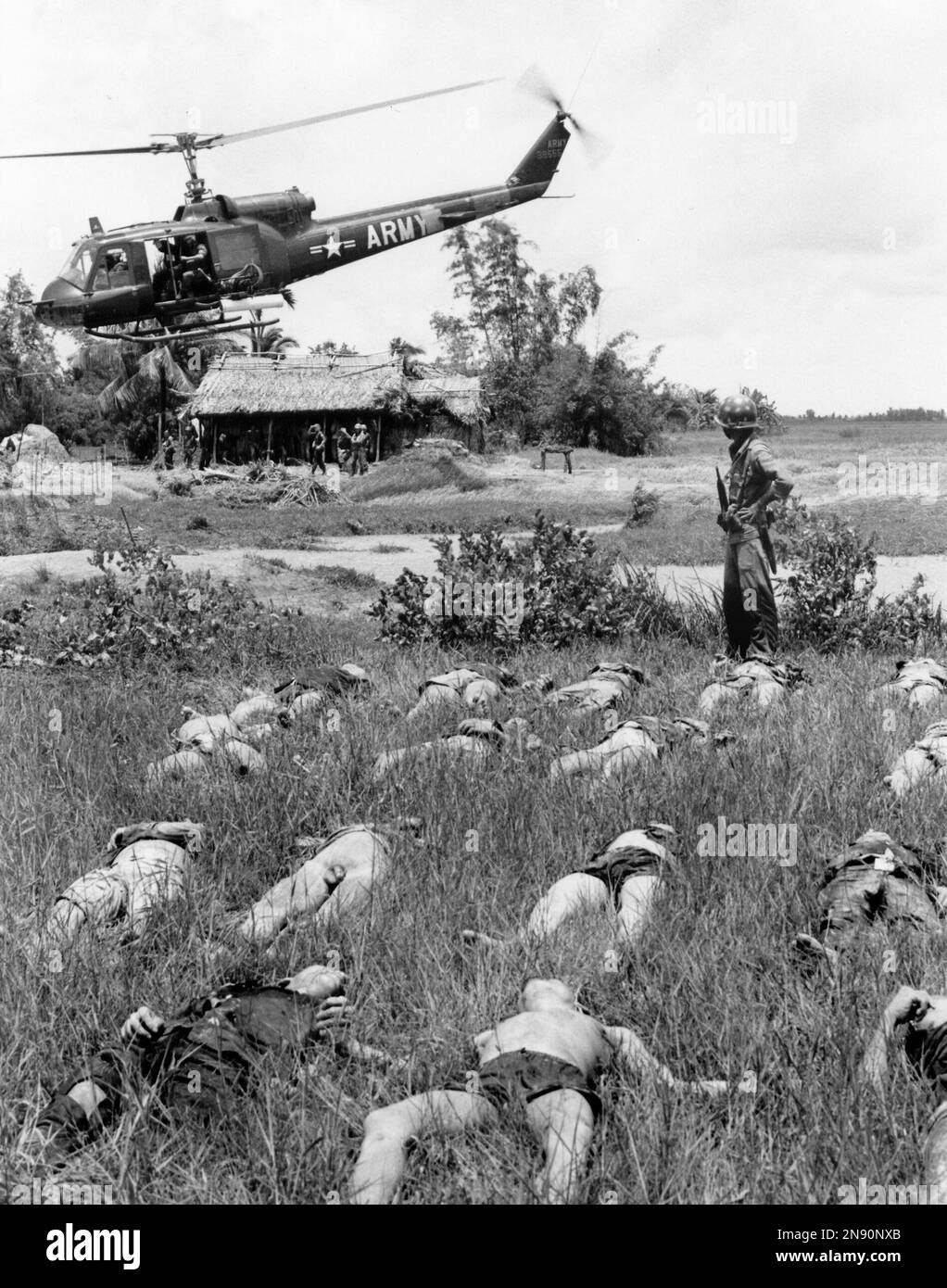 A U.S. Army helicopter flies over the bodies of Viet Cong guerrillas ...