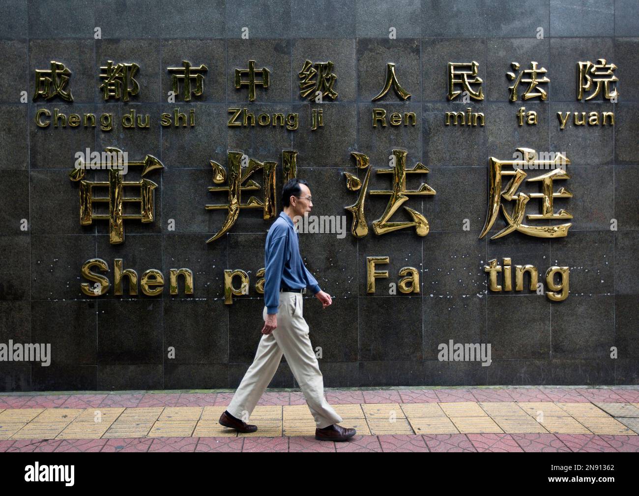 A Chinese man walks past the Chengdu Intermediate Court, where Wang ...