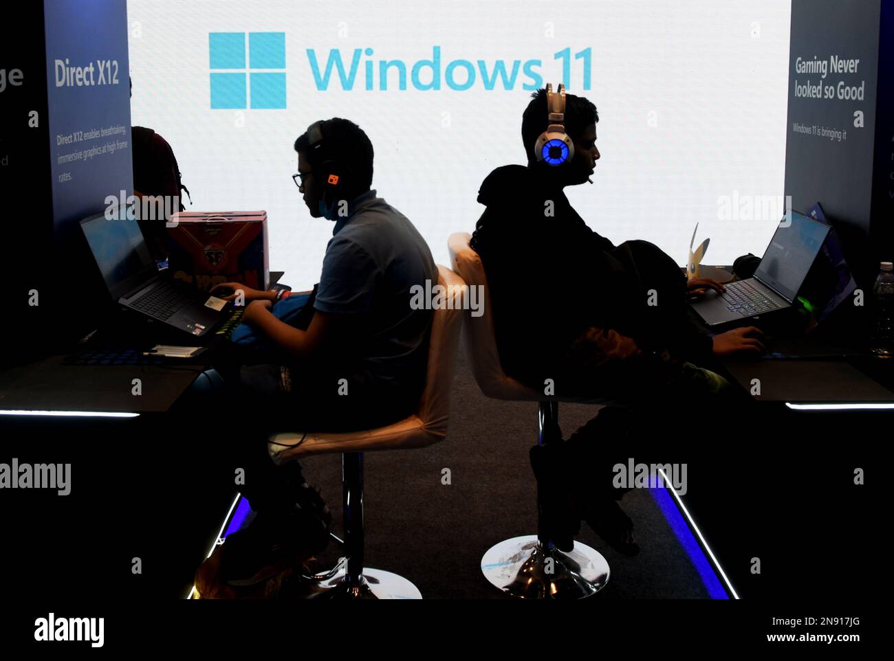 People play games in a Microsoft Windows 11 stall at Comic Con in ...