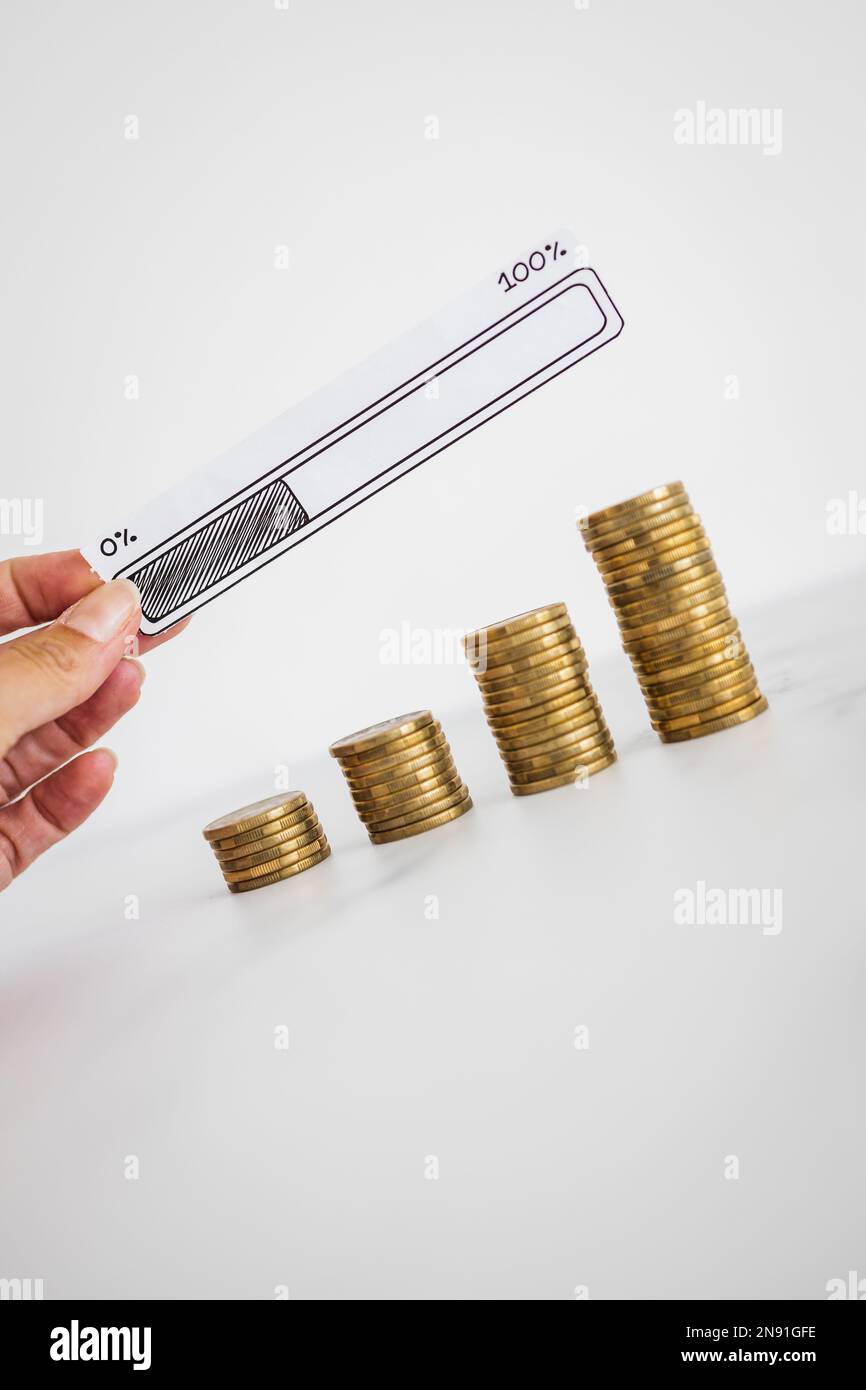 stacks of progressively increasing coins with hand holding progress bar ...