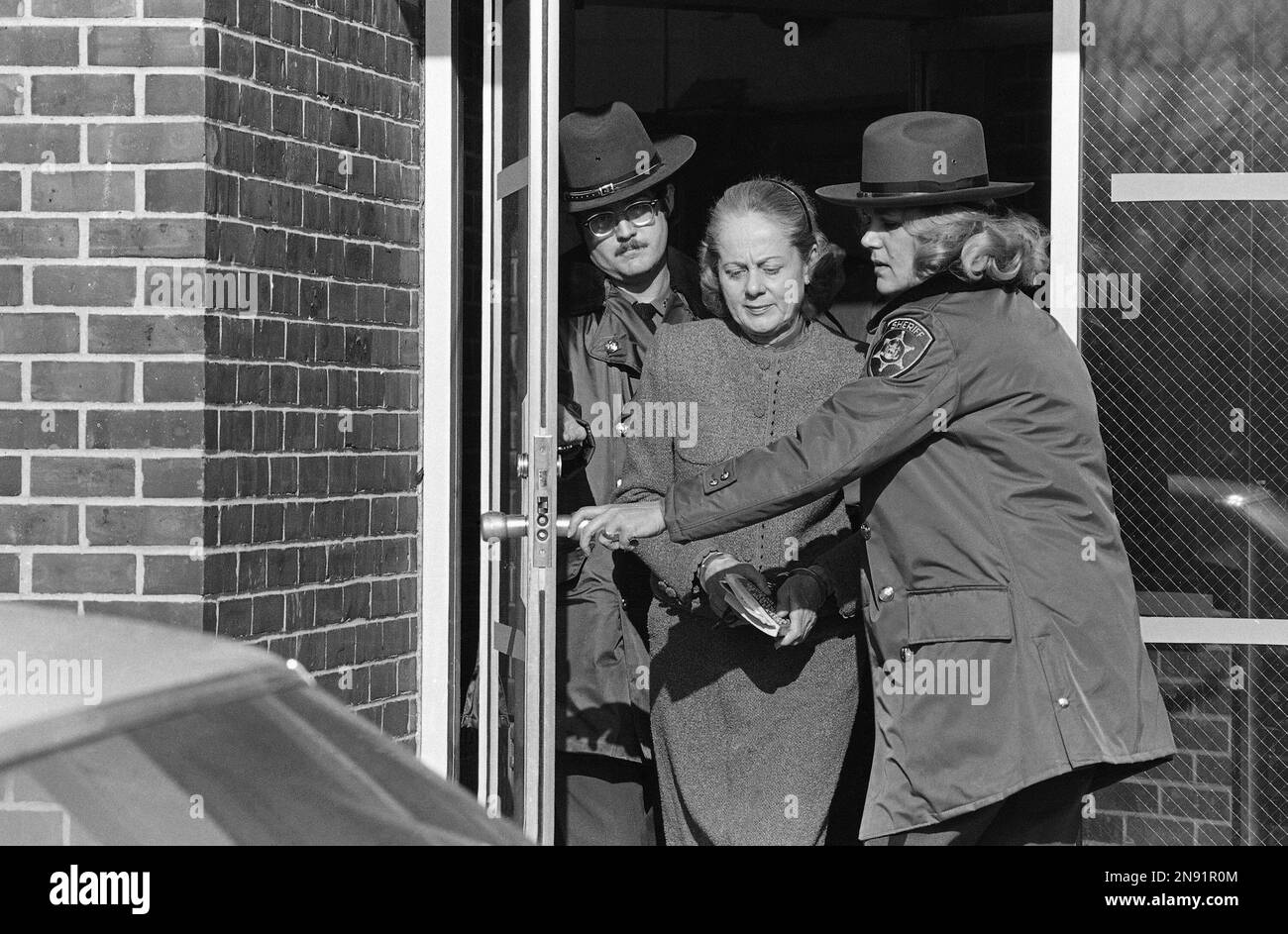 Jean Harris, handcuffed and carrying a book, leaves the Westchester ...