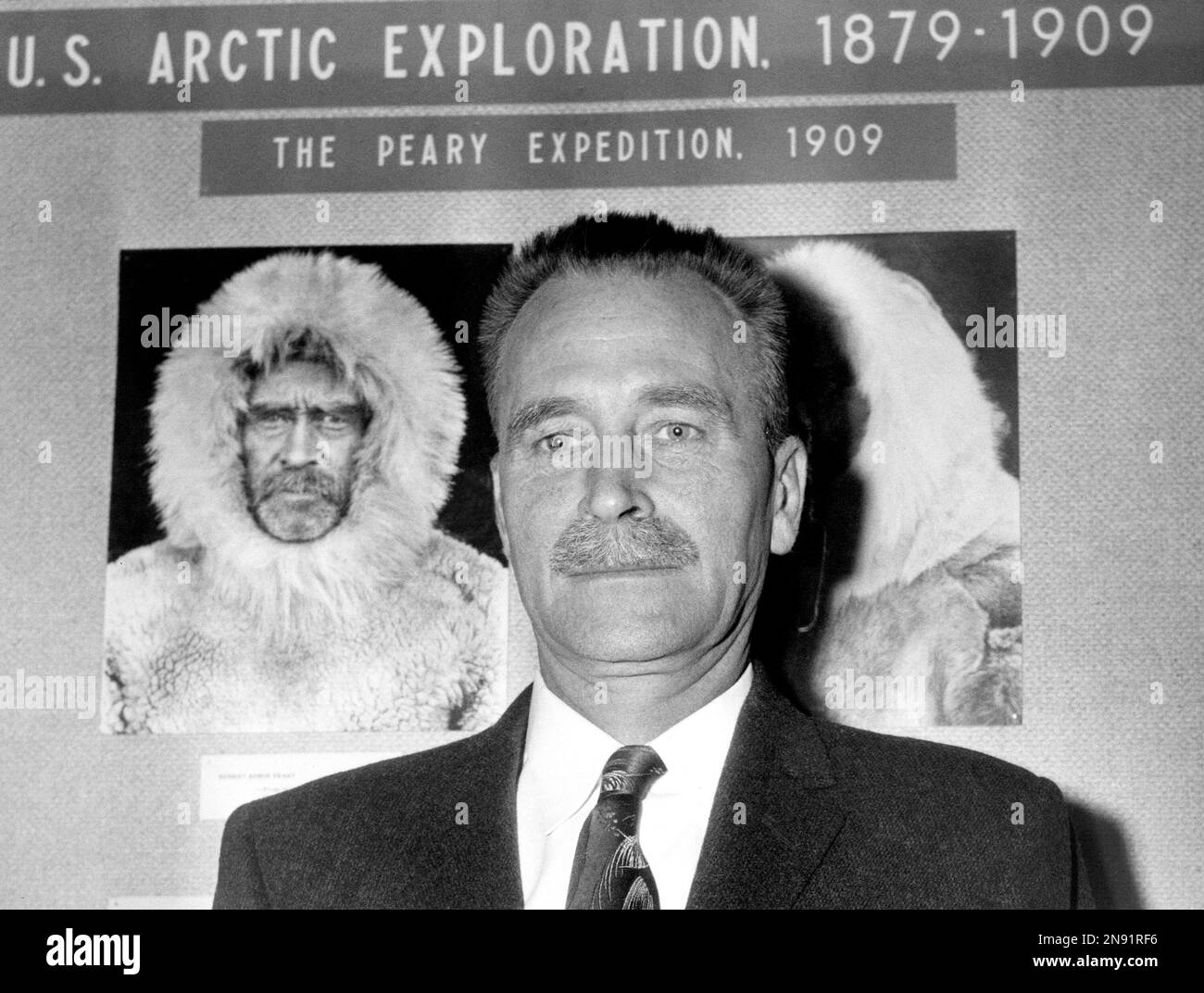 Robert E. Peary, Jr., poses beside a picture of his famous father ...
