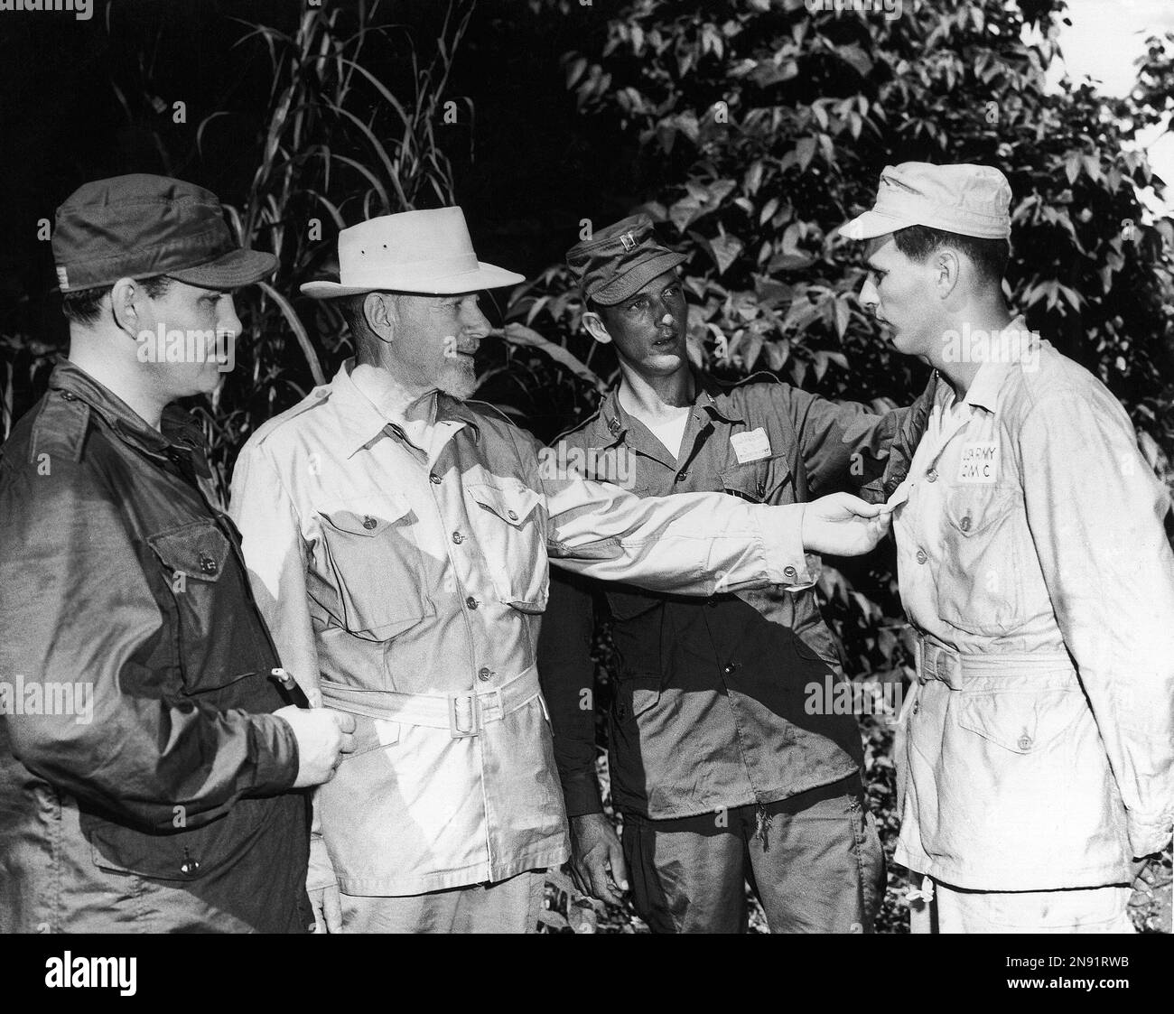 Quartermaster corps experts examine one of the uniforms used in tests ...