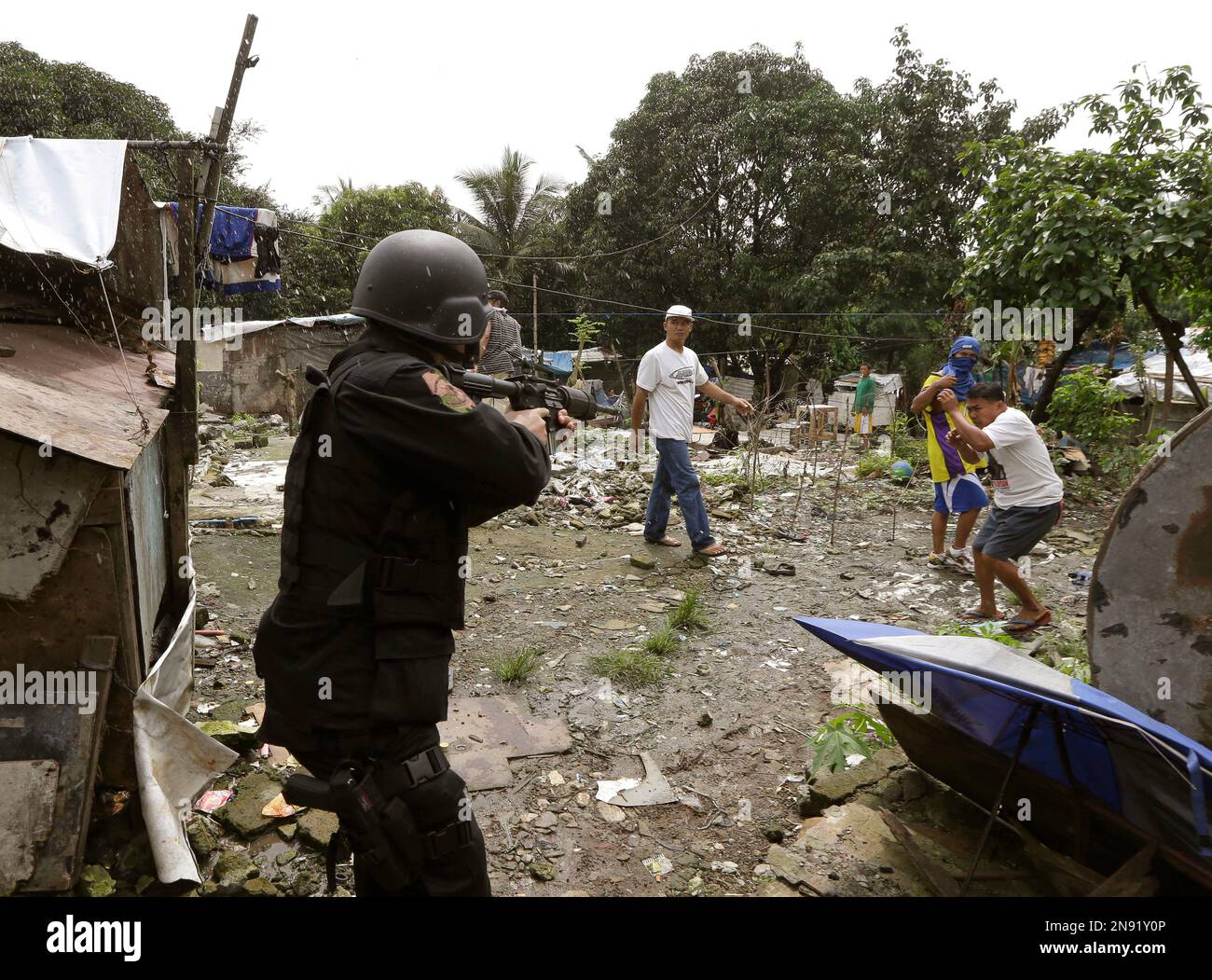 A member of the Philippine National Police SWAT team aims his rifle at ...