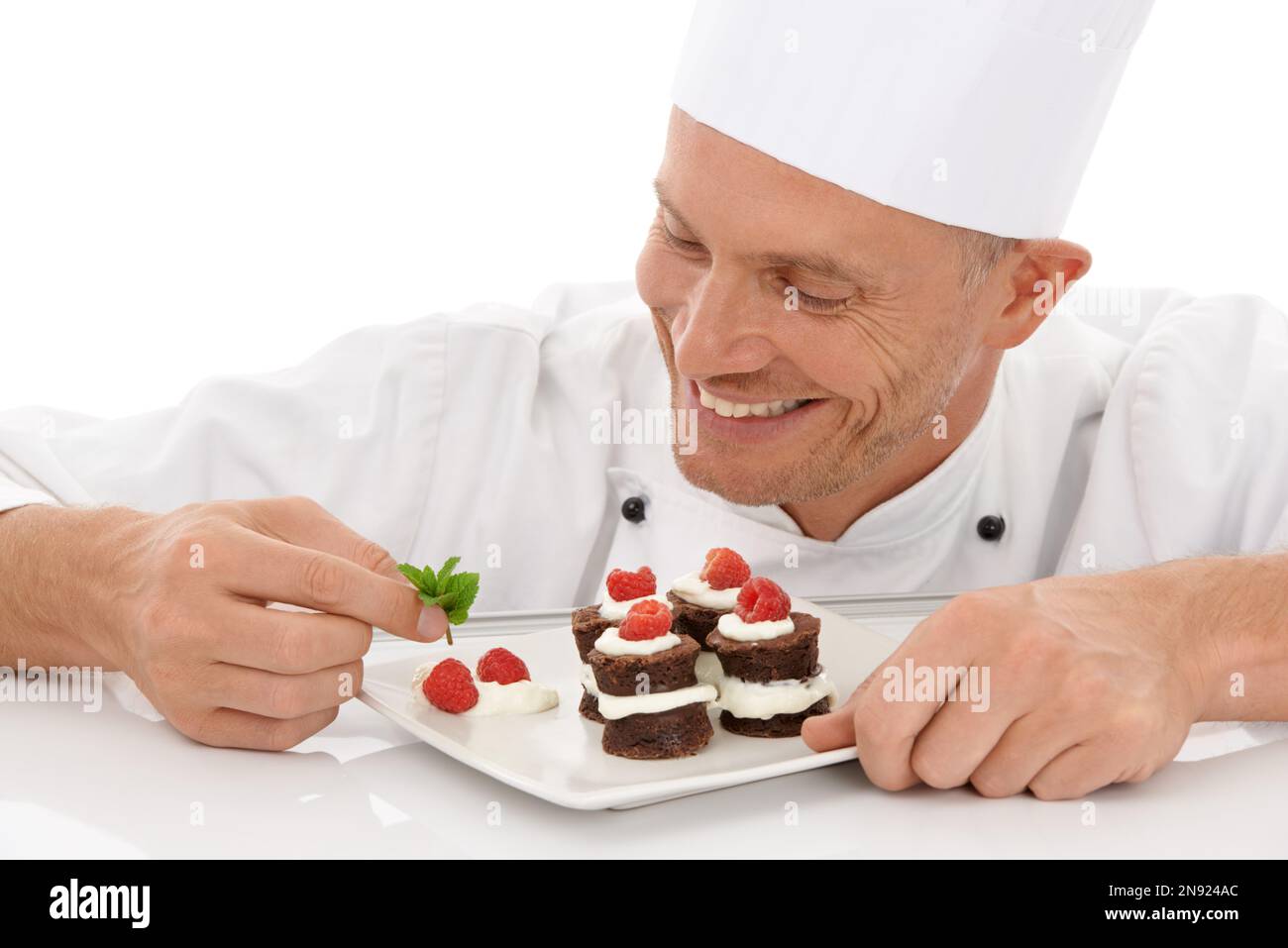 Baking, smile and chef with a dessert for catering isolated on a white ...