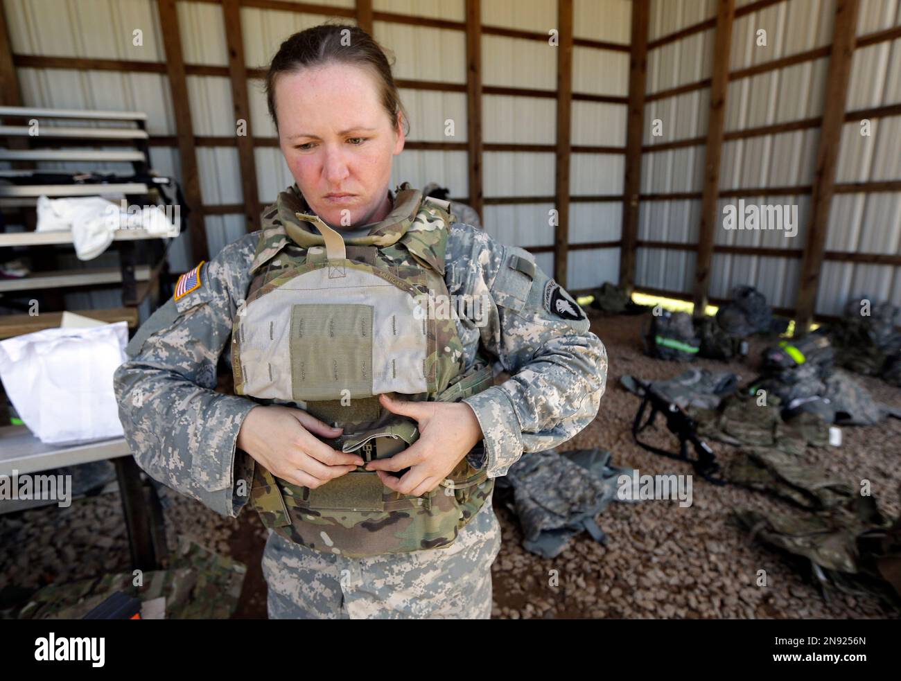 Spc. Sarah Sutphin removes her new body armor after training on a ...