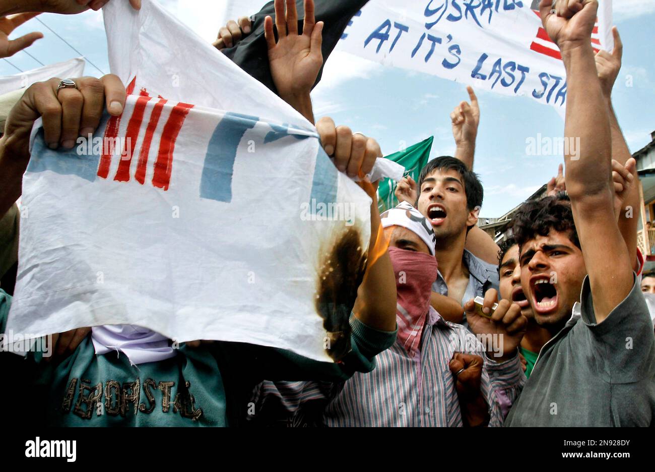 Kashmiri Muslim protesters burn a flag representing the U.S. and Israel ...