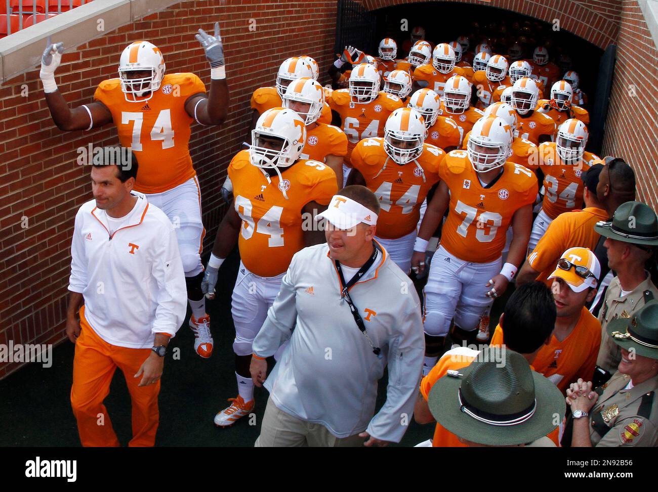 Tennessee head coach Derek Dooley, bottom left, leads his team onto the ...