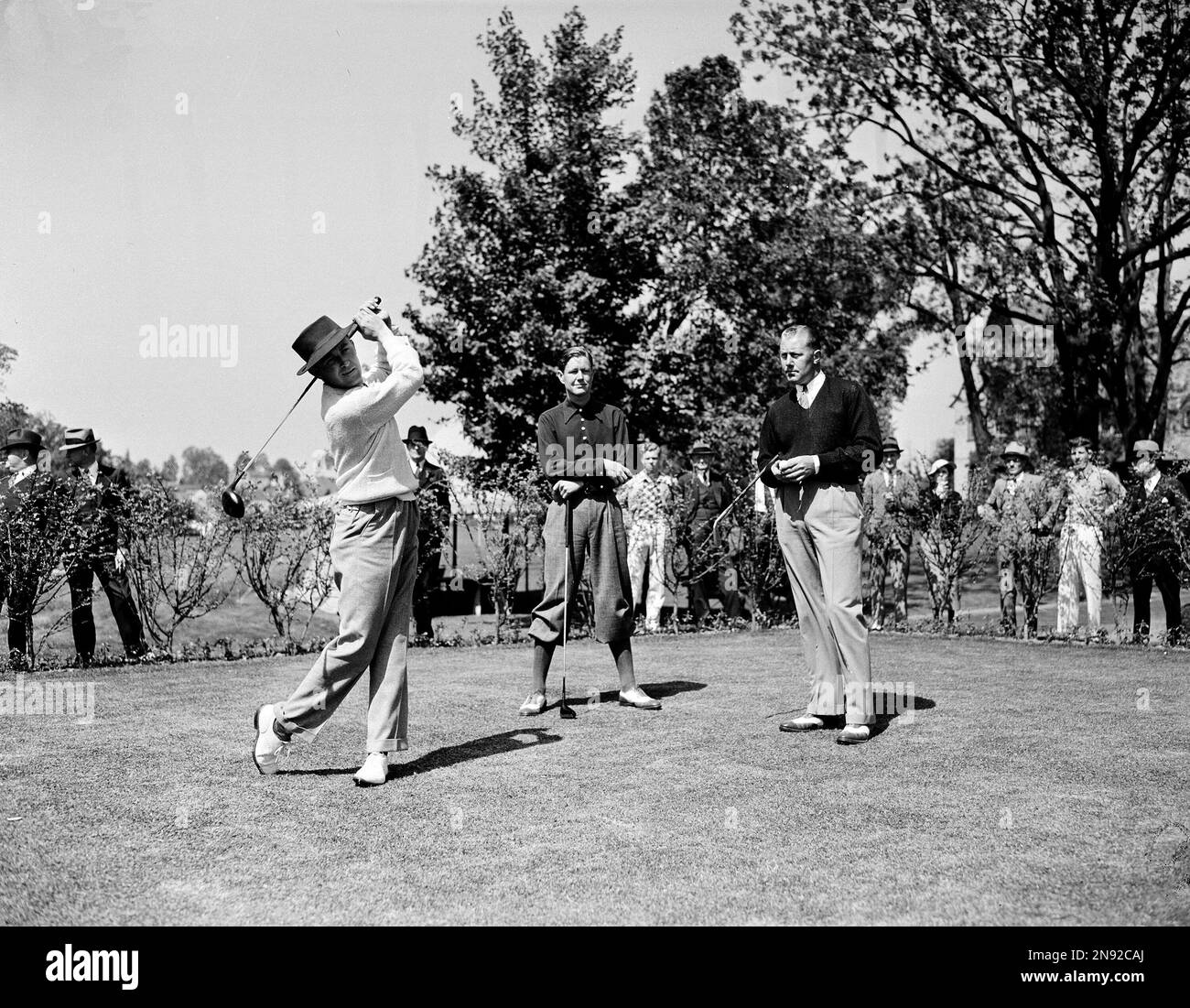 Golfer Paul Runyan drives as Byron Nelson, center, and Clarence Clark ...