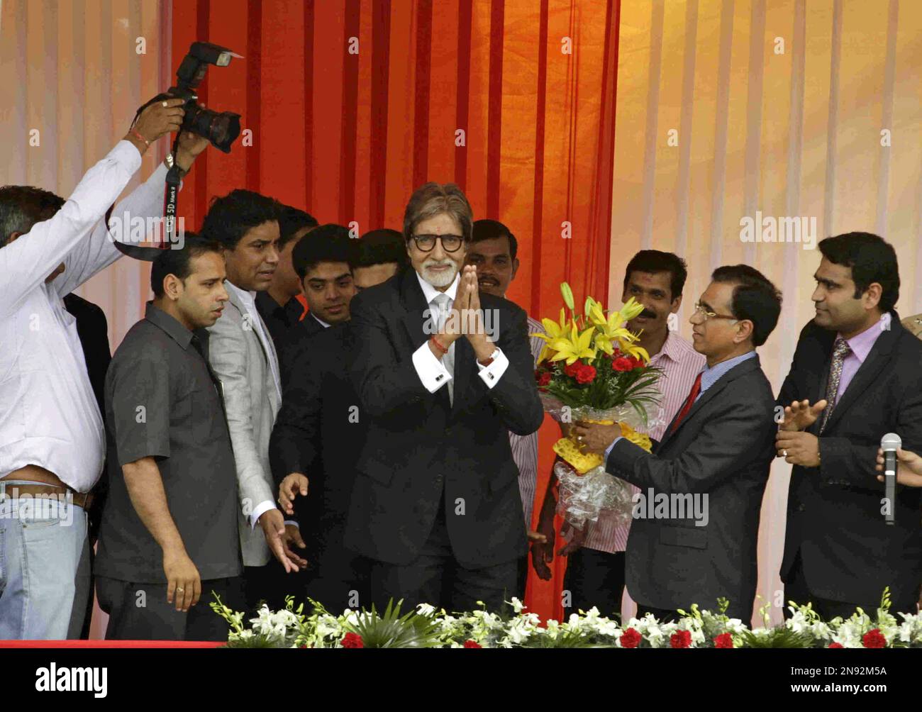 Bollywood star Amitabh Bachchan, center greets his fans, unseen, who ...