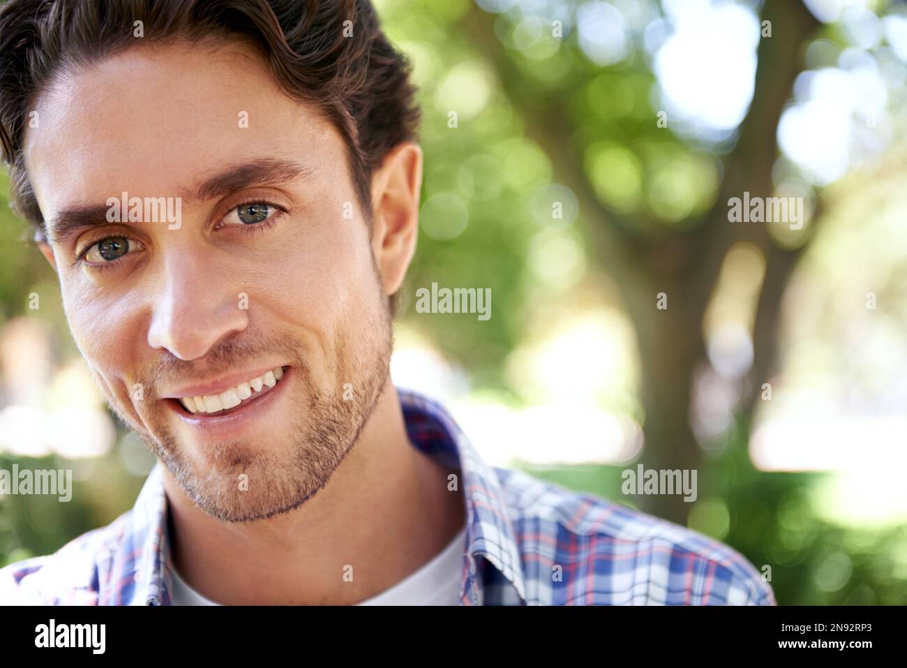 Happy, portrait and man at a park for travel, relax or day off ...