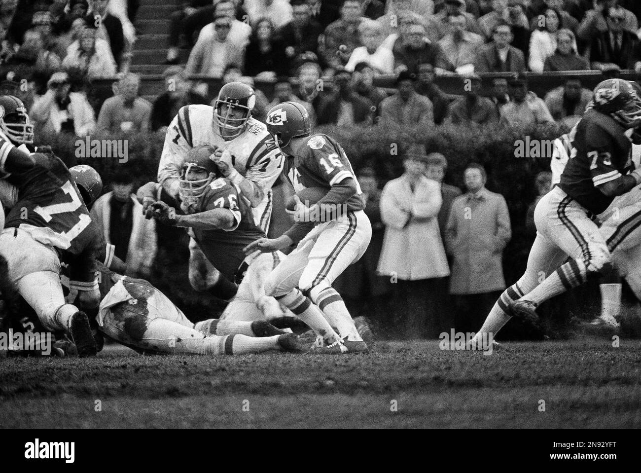 Kansas City quarterback Len Dawson, 16, craddles the ball as Mo Moorman ...