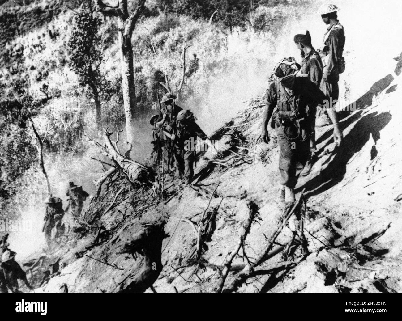 Allied troops clambering up a rough, precipitous hillside in typical ...