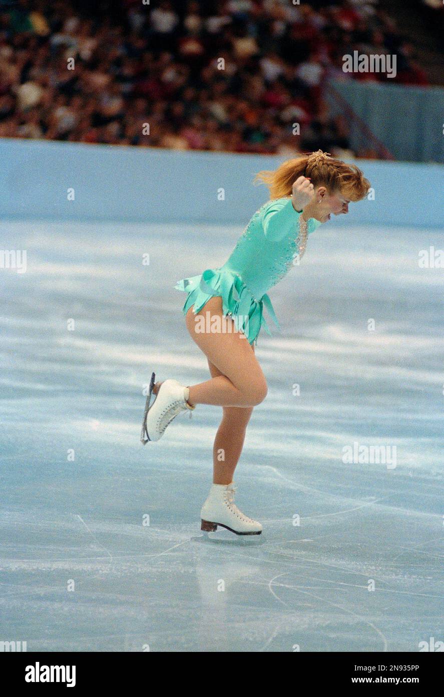 A happy Tonya Harding raises her fist and lets out a yell after she ...
