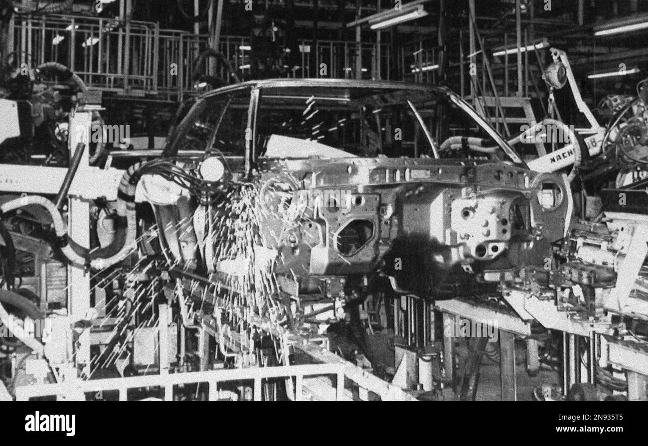 Sparks fly as industrial robot arms weld on the assembly line at Toyota ...