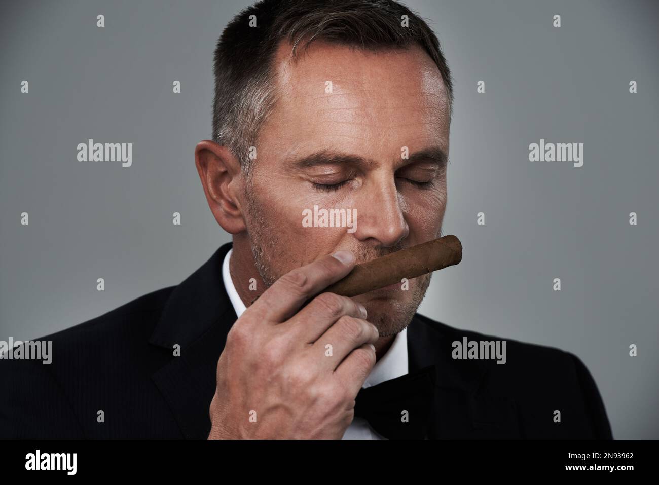 Wealth, vintage and face of man with cigars for smoking habit on gray background for luxury ...