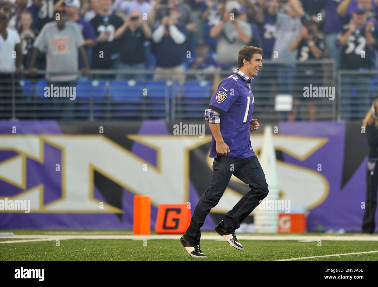 Olympic swimmer Michael Phelps runs onto the field before an NFL ...