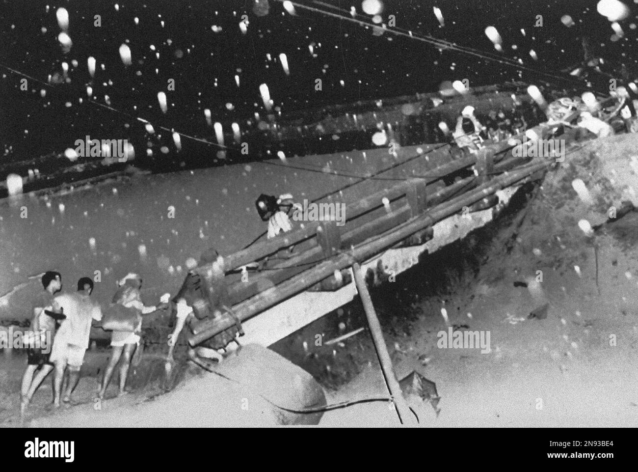People use ropes as they try and cross a bridge, damaged by typhoon ...
