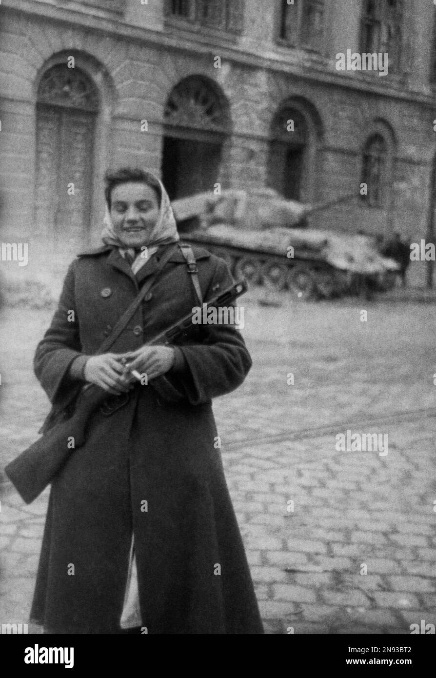 A Hungarian woman totes a Russian machine-gun in the street during the ...