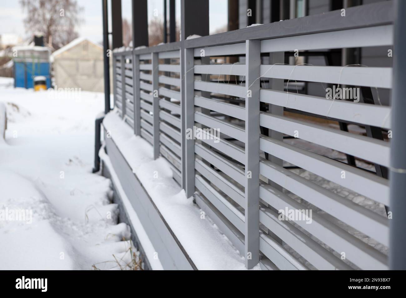 Wooden, grey painted railing of the veranda, winter season, close up ...