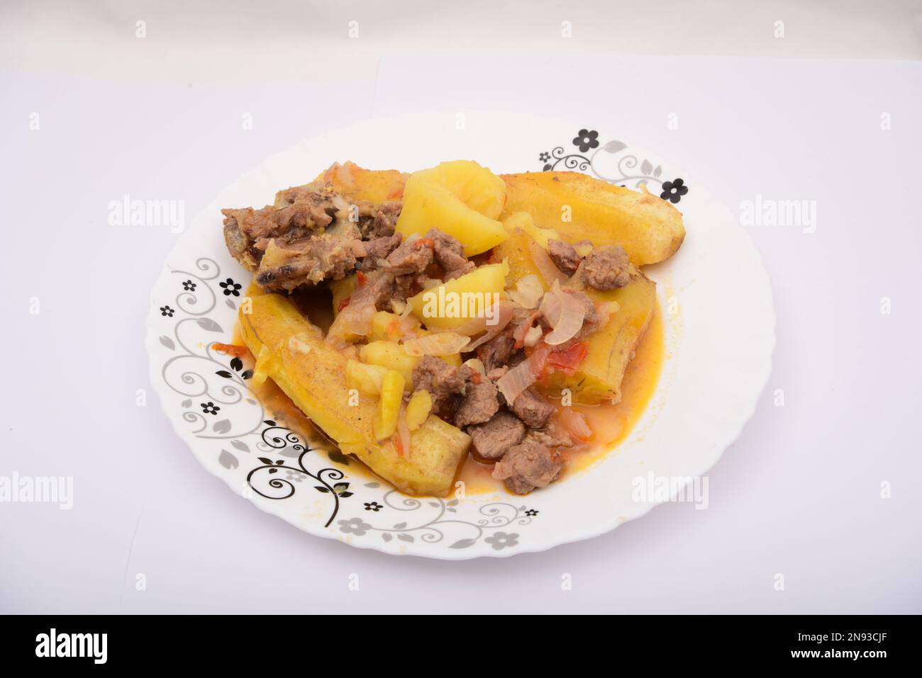 A plate of served African meal, Spaghettis and wet matoke fried with ...