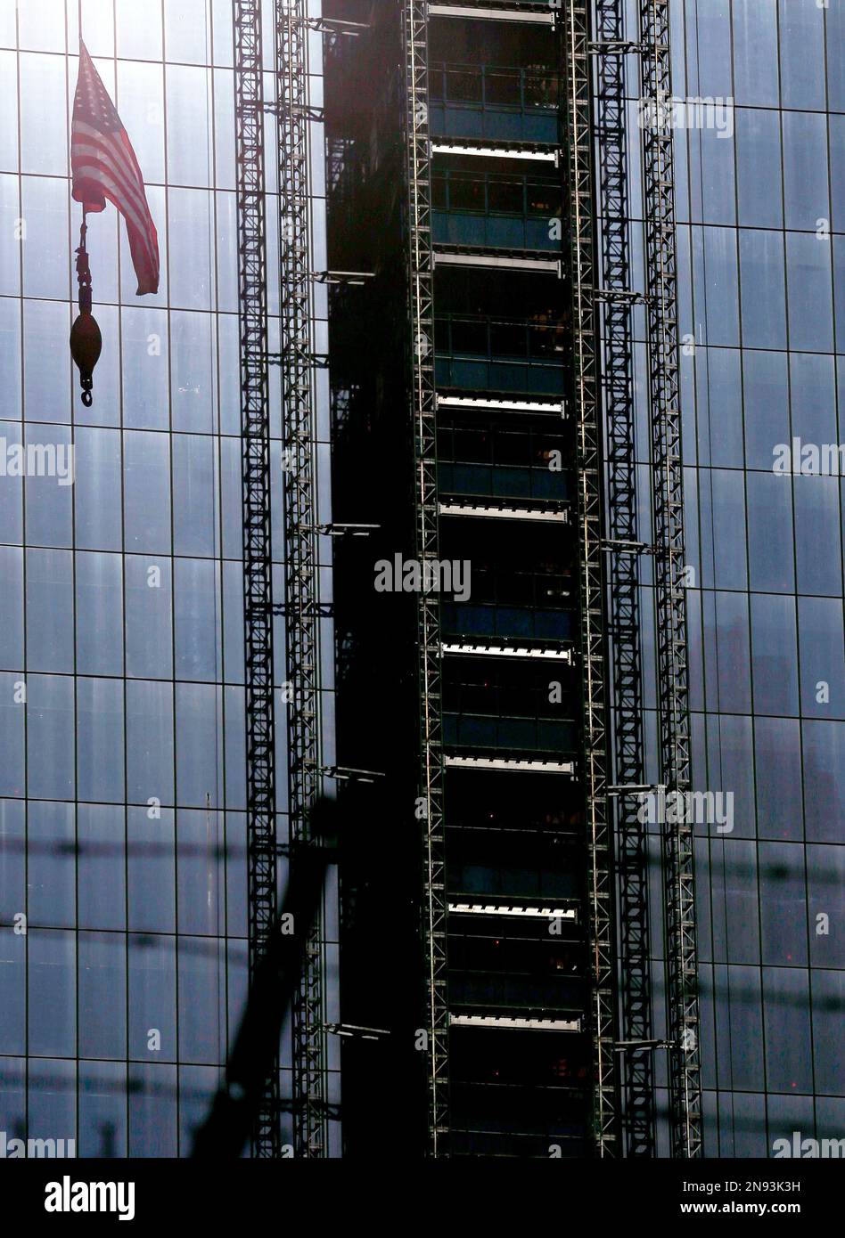 A United States flag hangs from a crane on the side of the construction ...