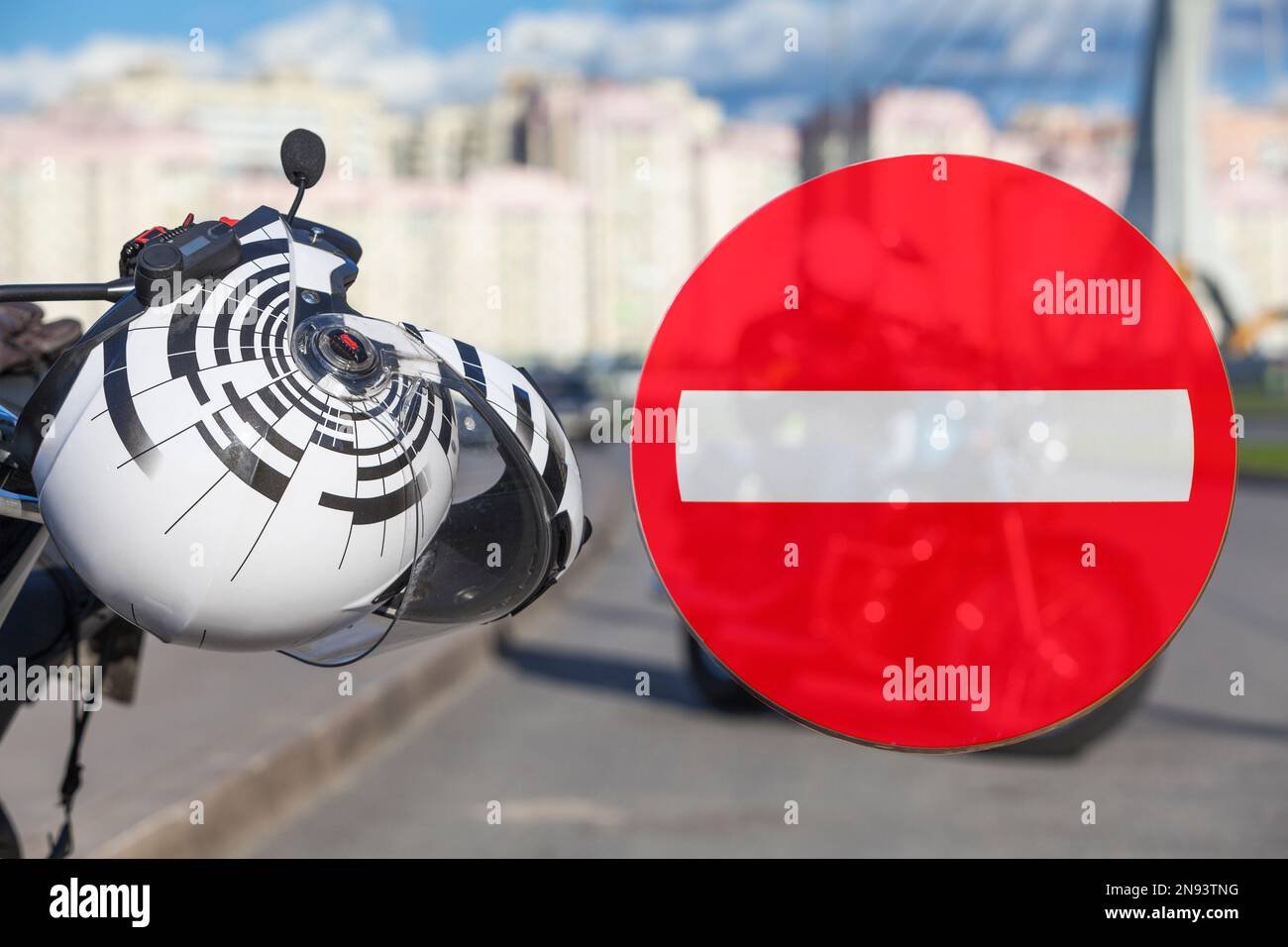 A motorcycle helmet hangs on the handlebars of a parked motorcycle ...