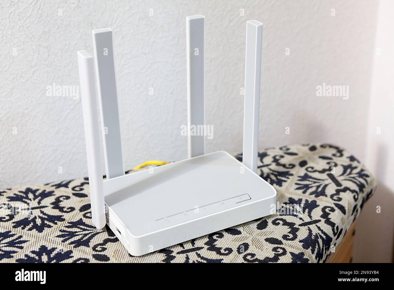 White home dual band router with four antennas is in an apartment hall ...