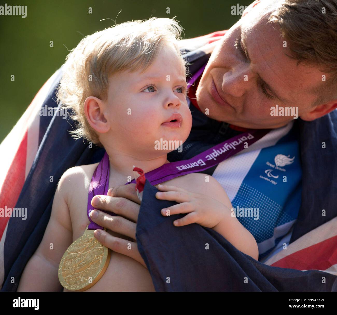 Gold medalist Britain's David Weir sits with his son Mason on his lap ...