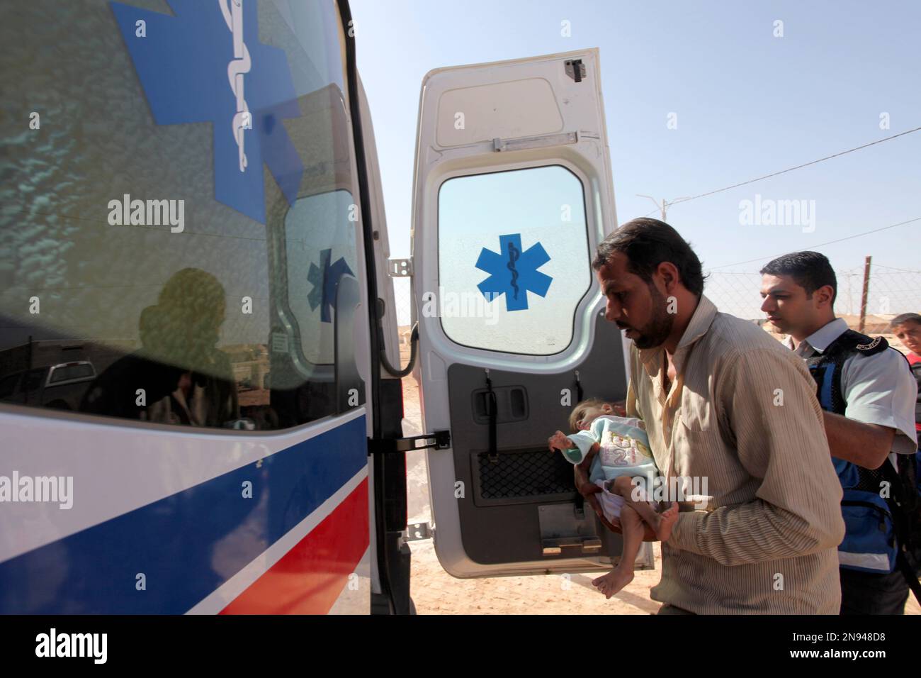 Syrian refugee Abo Jamal carries his critically-ill newborn child to an ...