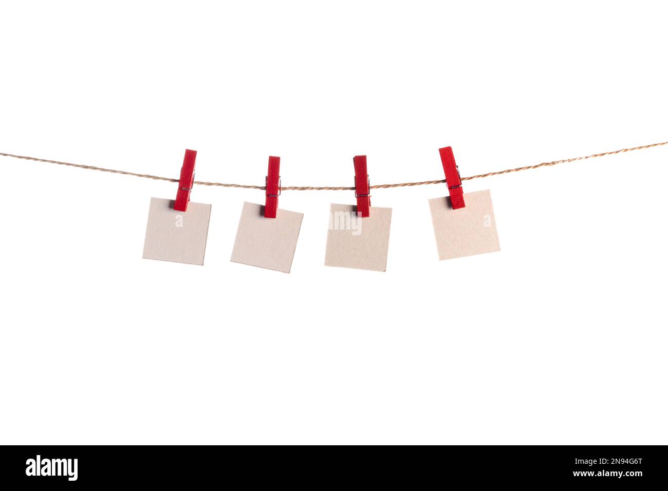 Set of four blank paper notes held on a string with clothespins ...