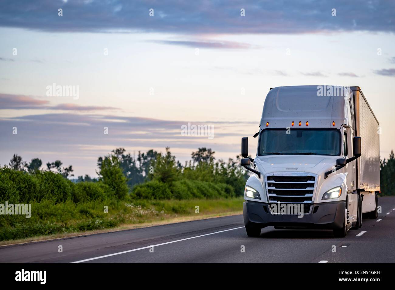 Industrial long hauler big rig white semi truck tractor with turned on ...