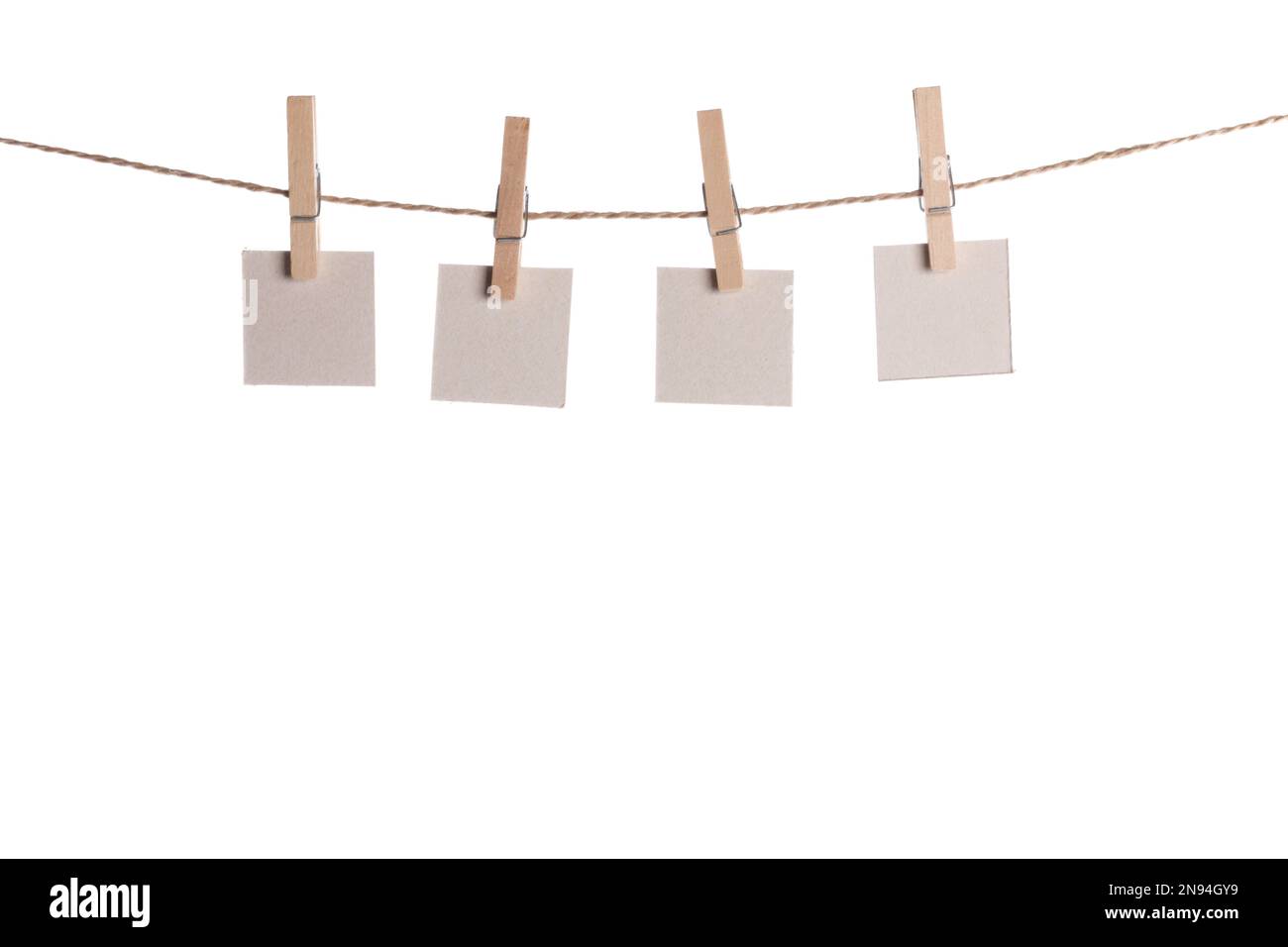 Set of four blank paper notes held on a string with clothespins ...
