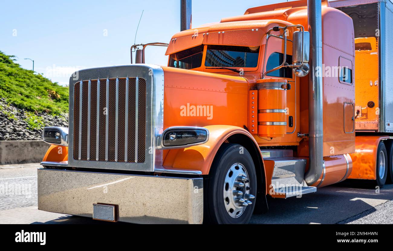 Industrial classic American long hauler big rig orange semi truck ...