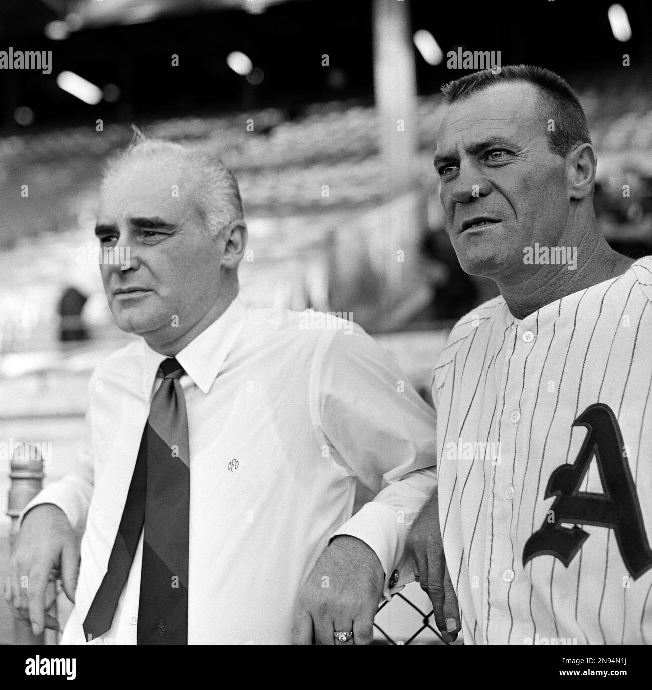 Hank Bauer, Kansas City Athletics' manager, right, poses with clubs ...