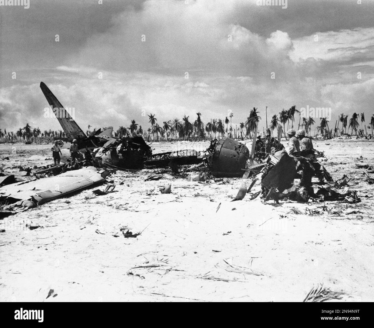 Some of the landing soldiers inspect what is left of the Japanese Zero ...