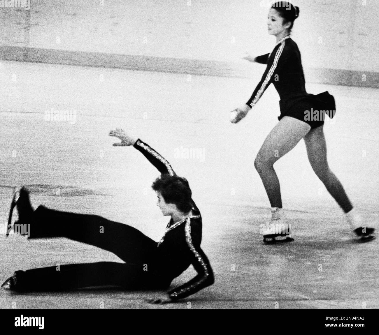 Randy Gardner hits the ice as his partner Tai Babilonia skates near him ...
