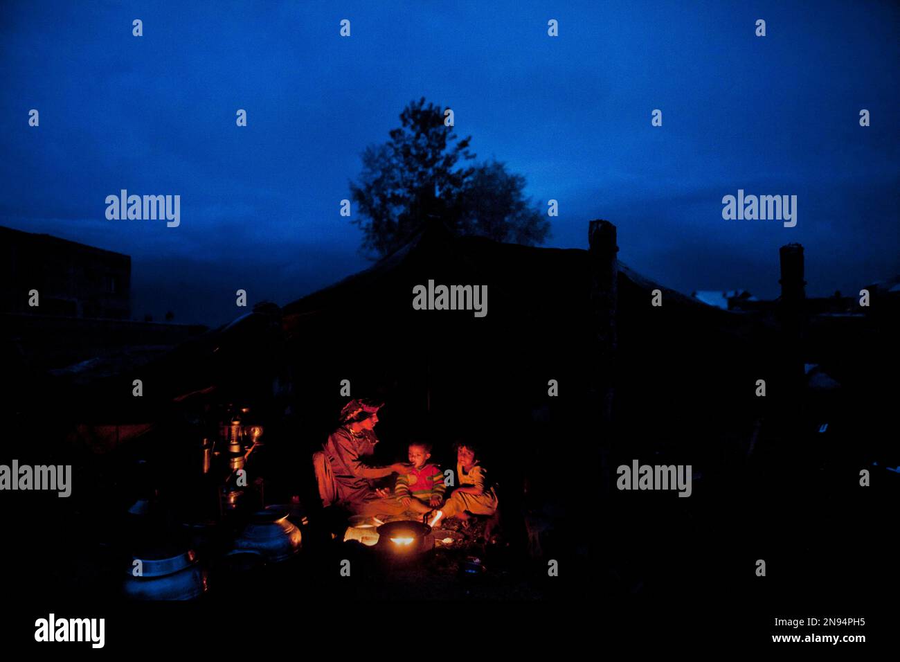 A Bakarwal woman feeds her children inside a temporary camp in Kangan ...