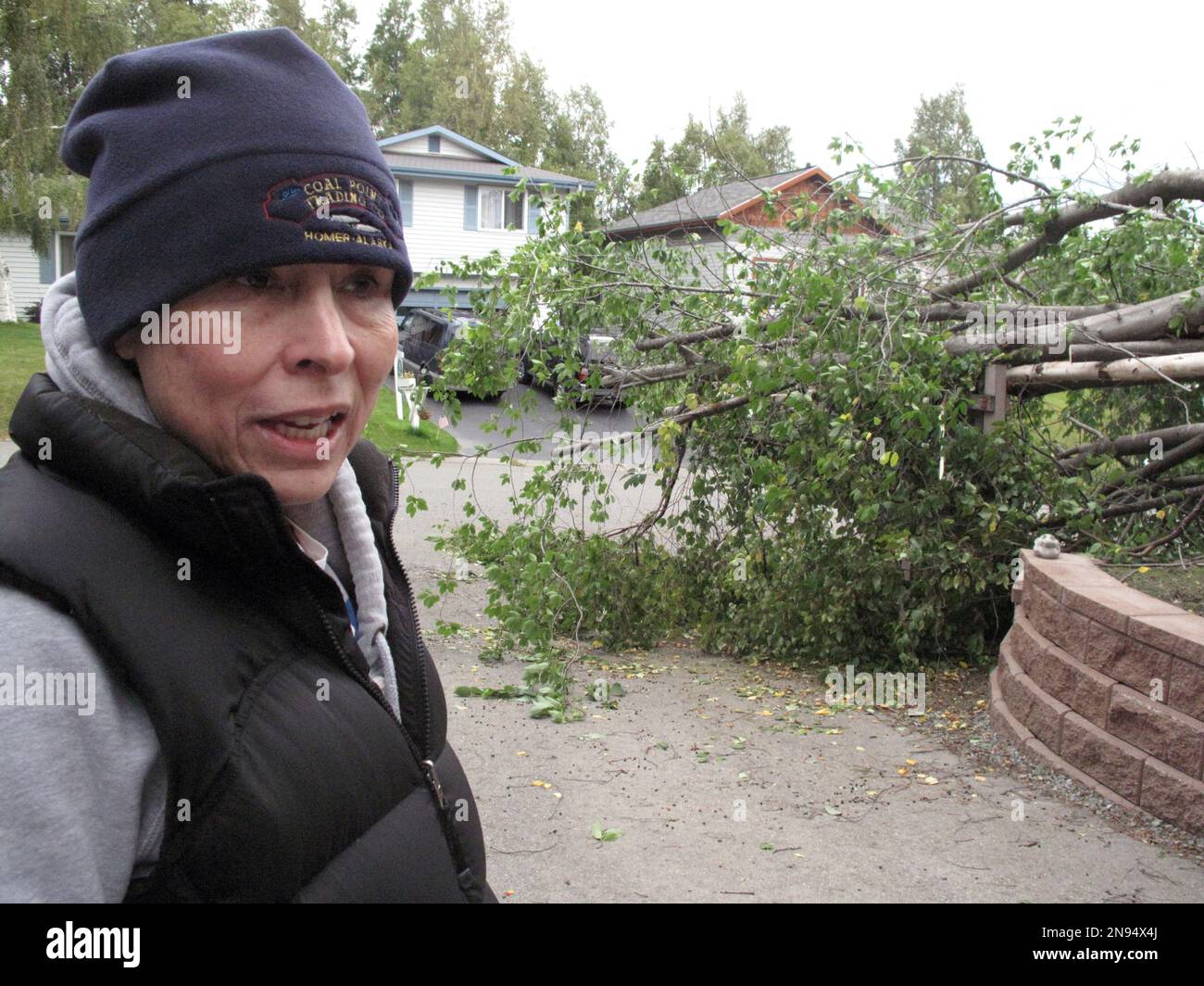 Diana Patton stands near two trees that fell over in her front yard ...
