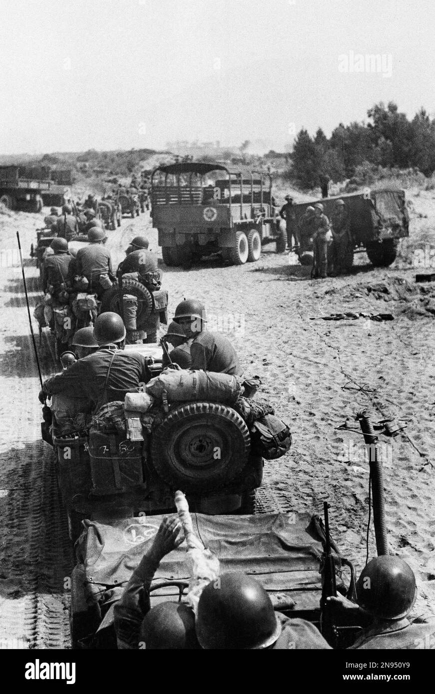 A long line of jeeps carrying troops of the U.S. Fifth Army moves ...
