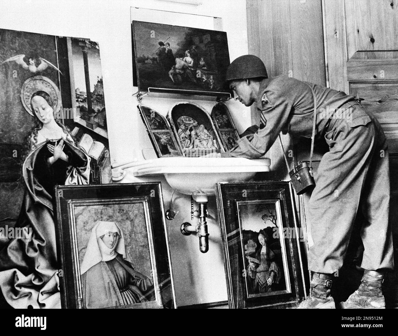 An American Soldier studies various paintings, one of them resting in a ...