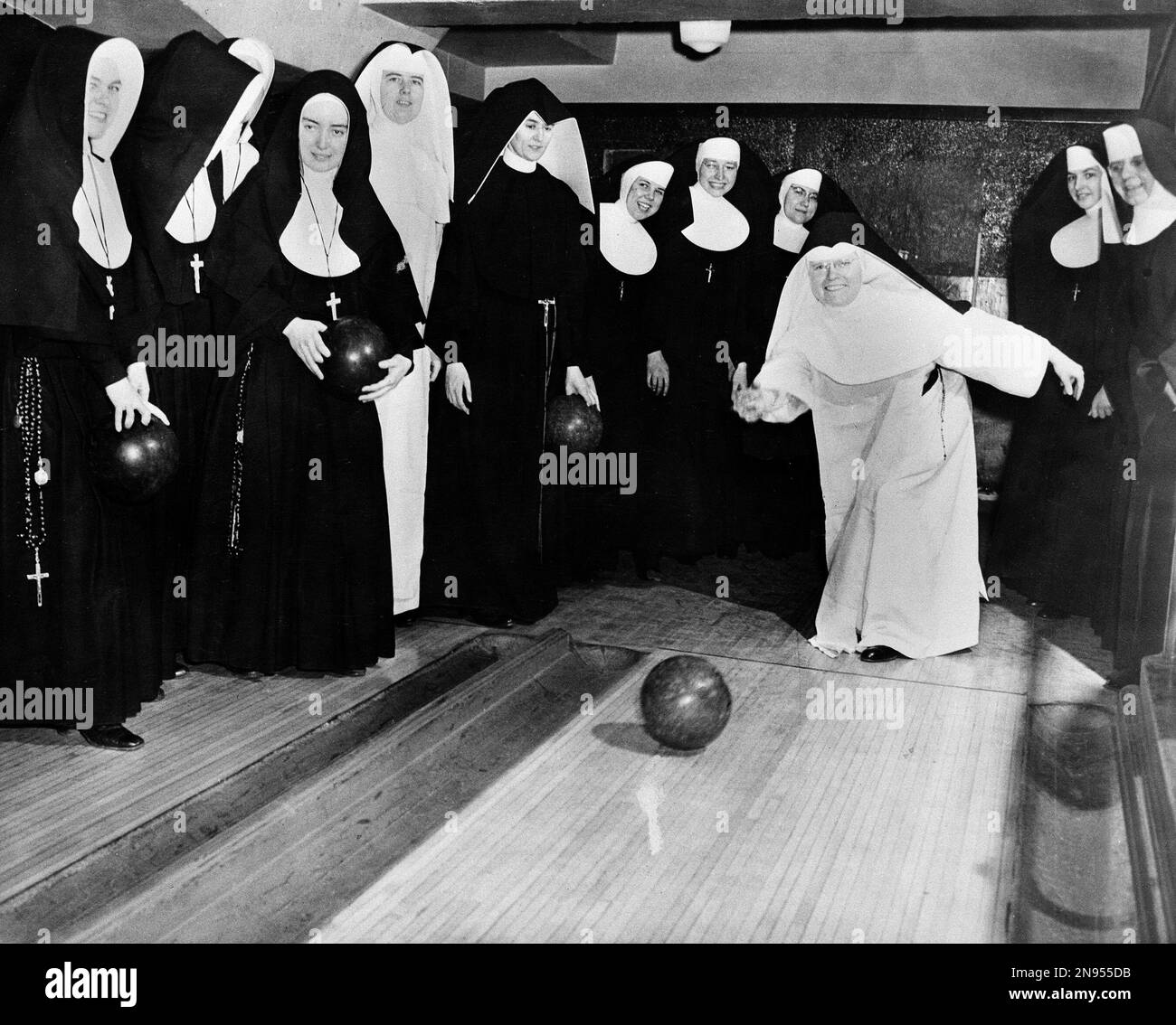 Sister Miriam Joseph follows through as she rolls a bowling ball in a ...