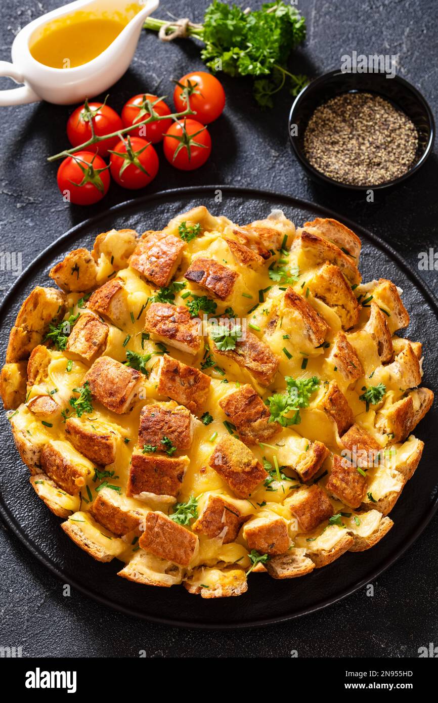 cheesy garlic crusty bread, pull apart whole round bread on black ...