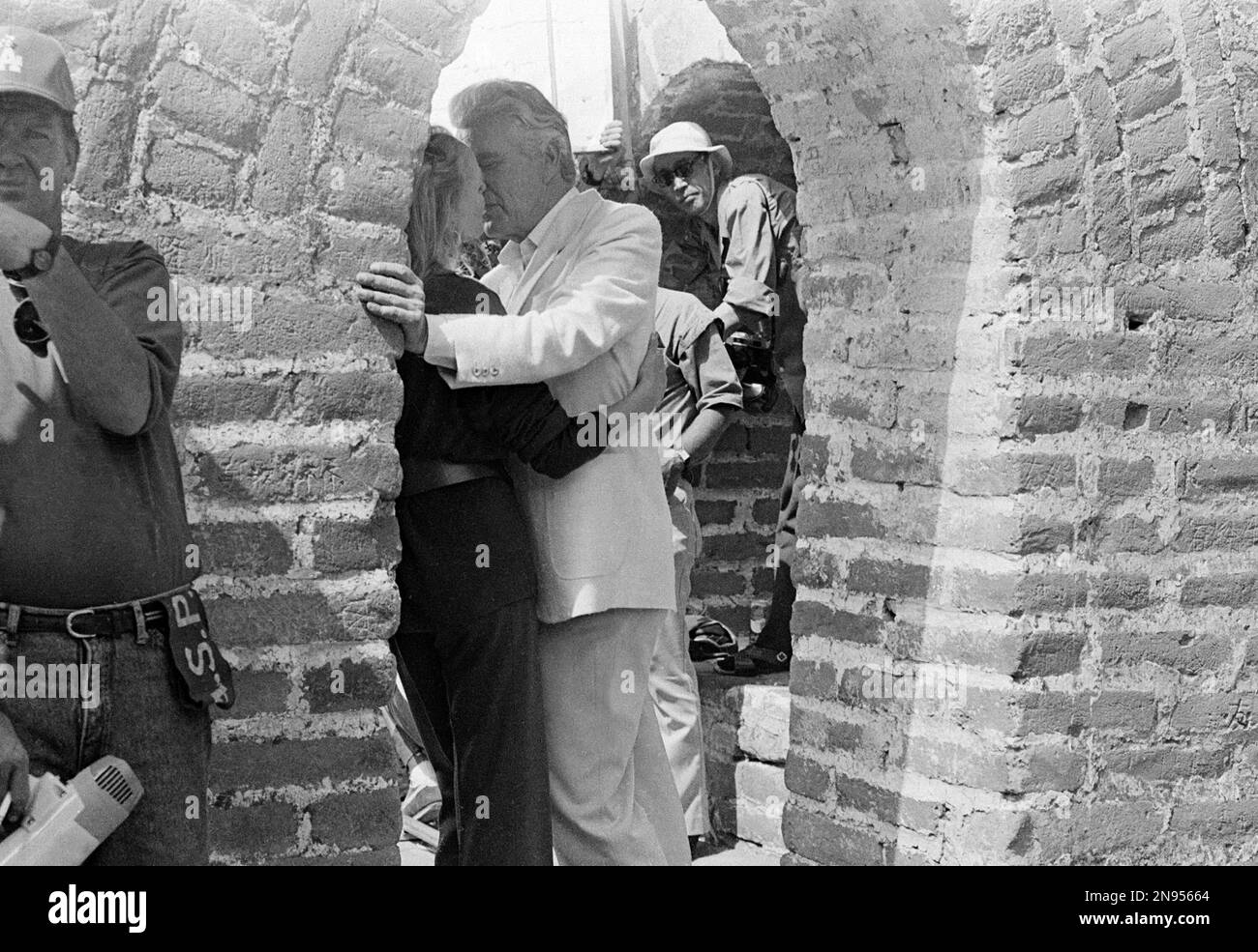 Actrees Ursula Andress puts her arms around John Forsythe as they ...
