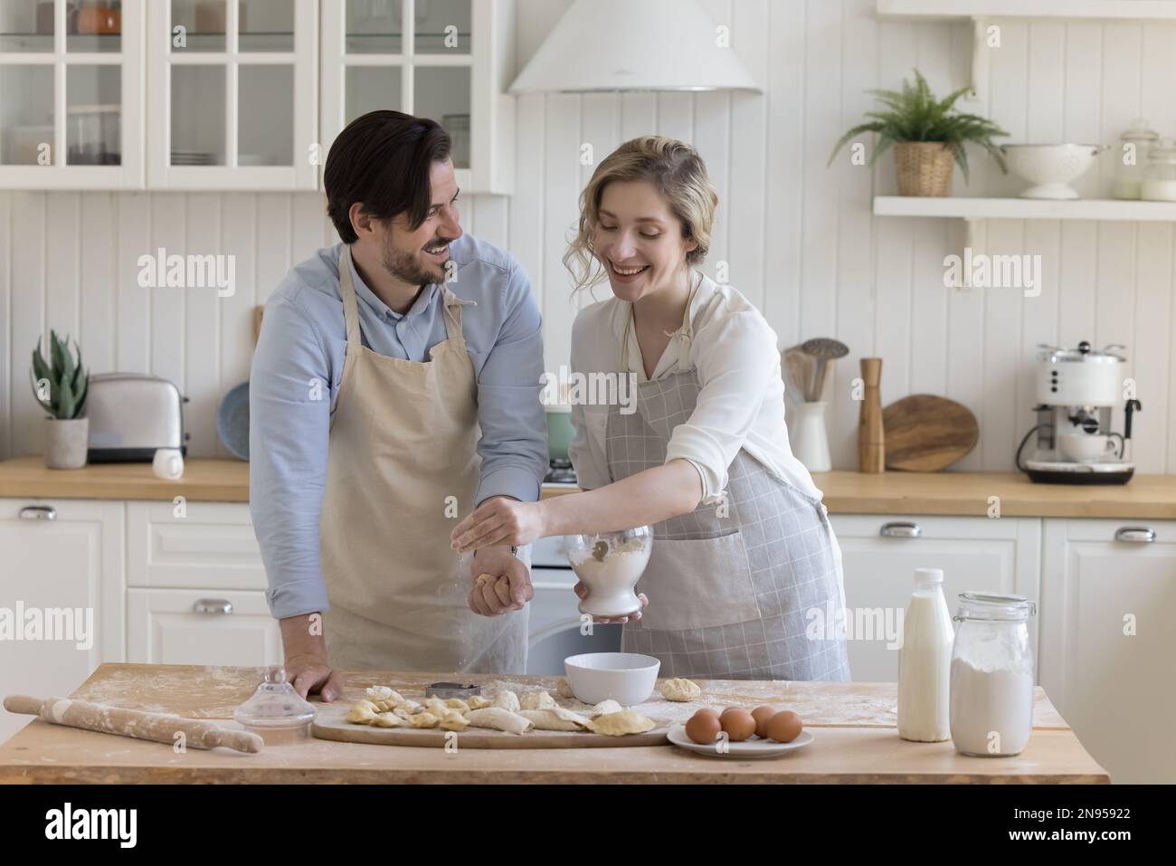 Happy positive young couple in love wearing aprons Stock Photo - Alamy