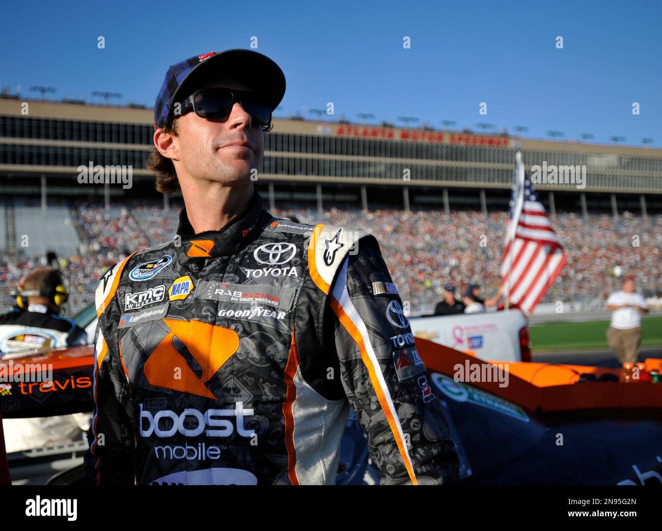 Travis Pastrana waits by his car before the NASCAR Nationwide Series ...