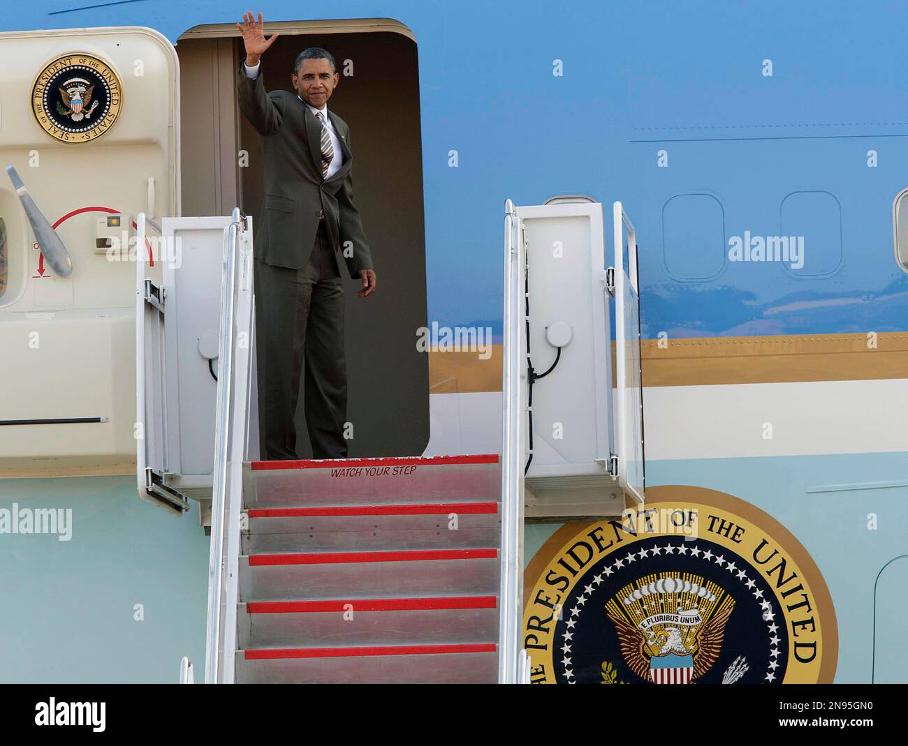 President Barack Obama waves from the doorway of Air Force One as he ...