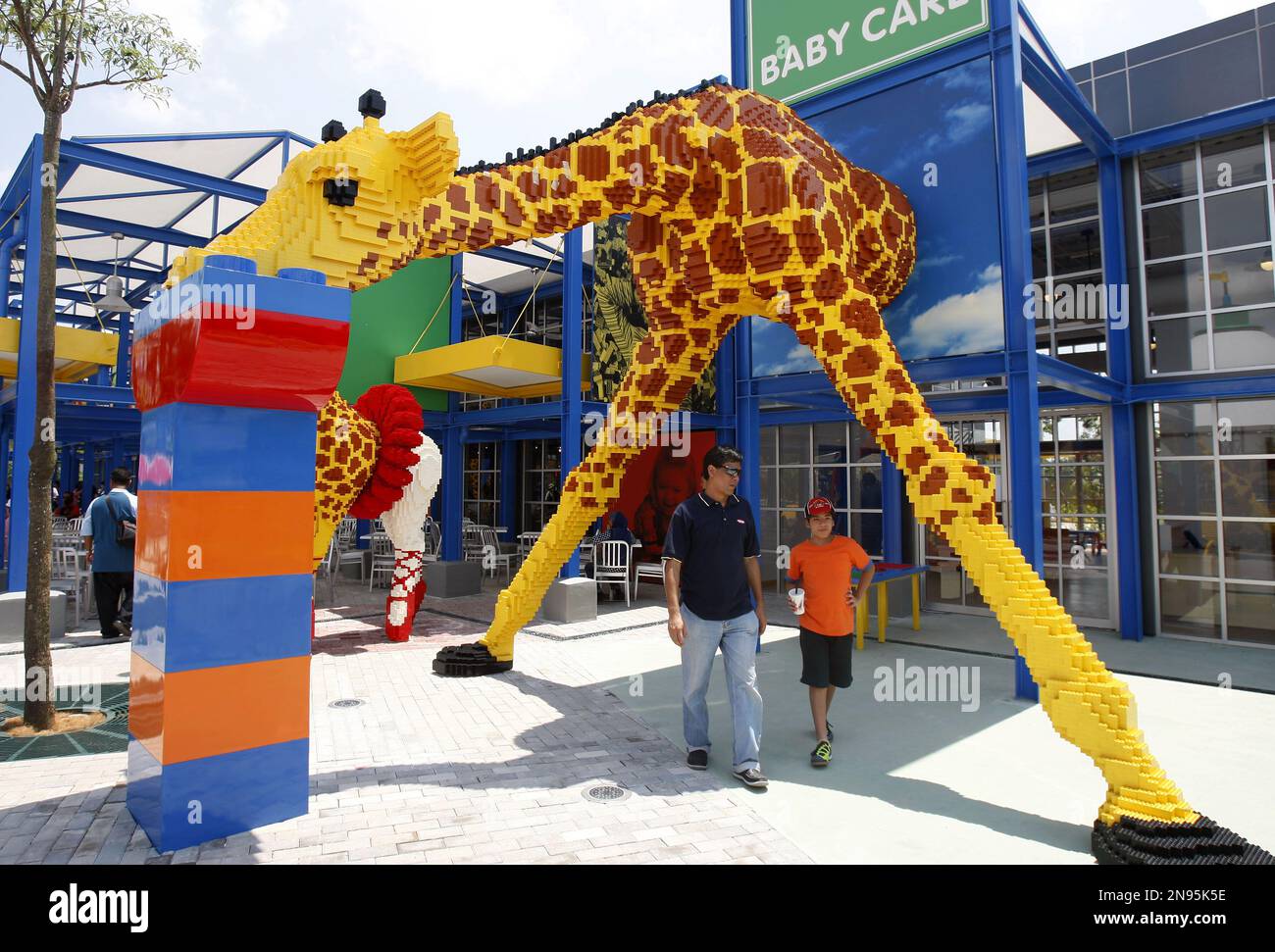 Guests walk past a giant giraffe made by Lego bricks during a preview ...