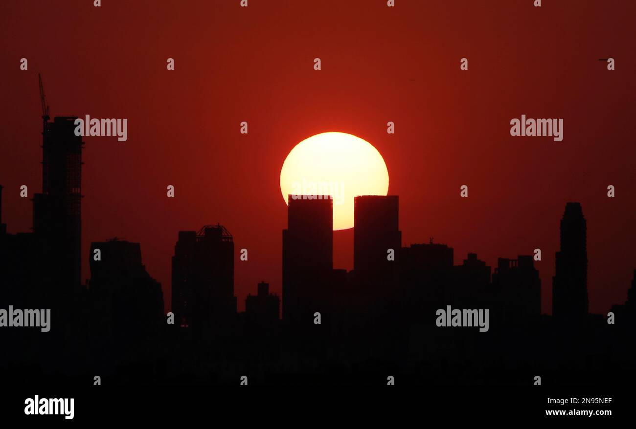 The sun sets behind the New York City skyline as seen from Arthur Ashe ...