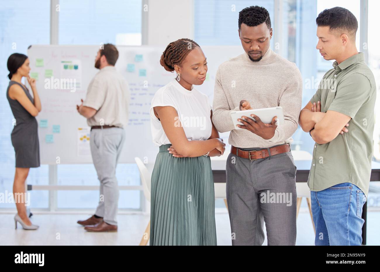 Optimising their tasks for the day. a group of businesspeople using a ...